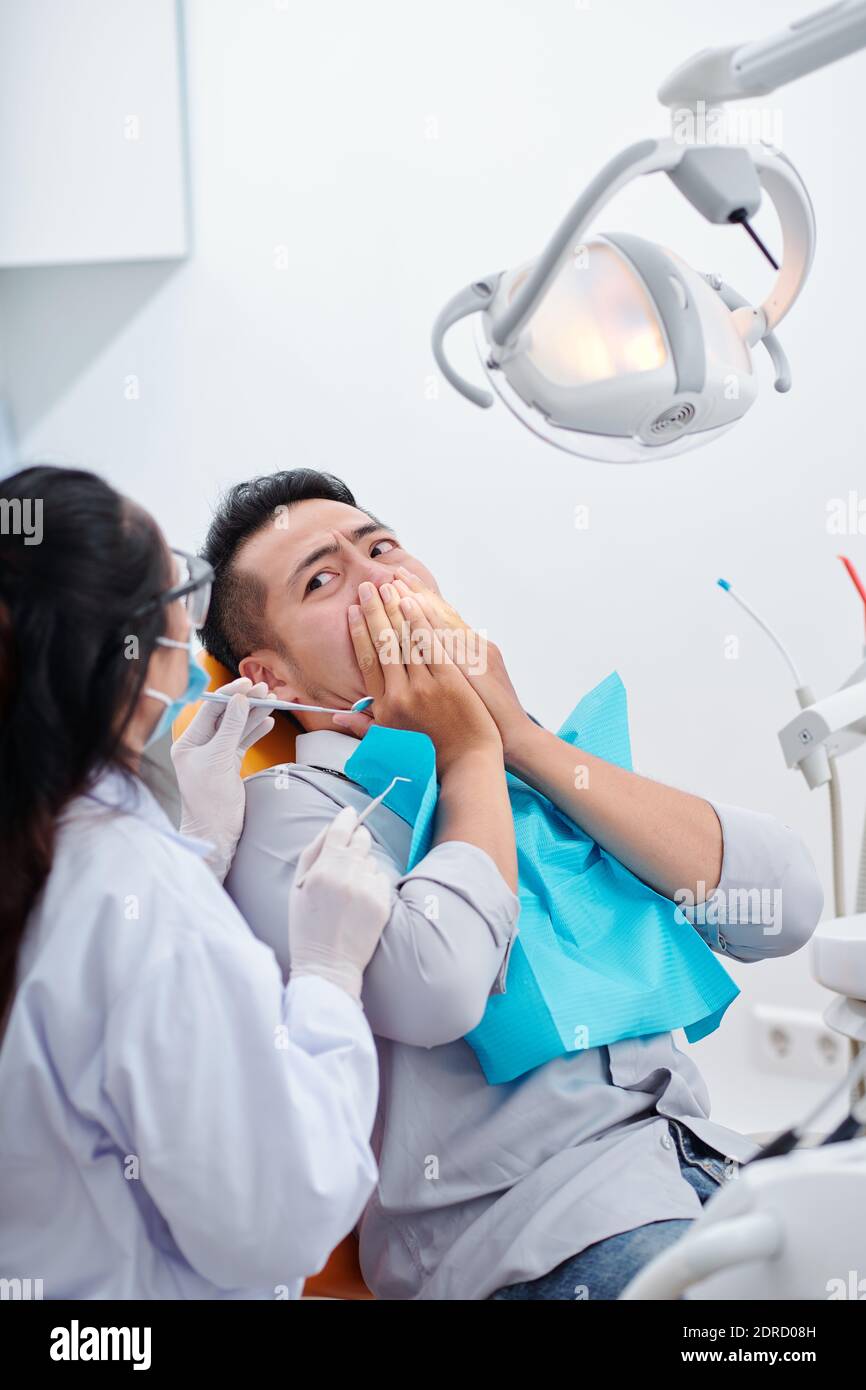 Man scared of teeth treatment Stock Photo - Alamy