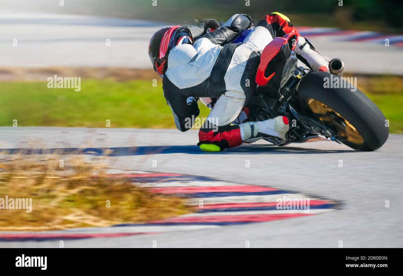 Motorcycle leaning into a fast corner on race track Stock Photo - Alamy