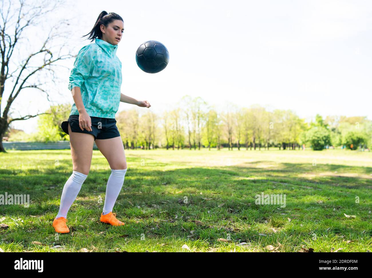 Young woman practicing soccer skills with ball Stock Photo - Alamy