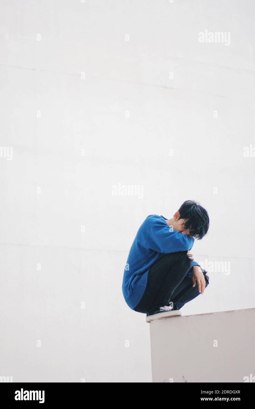 Indian man crouching on wall hi-res stock photography and images - Alamy