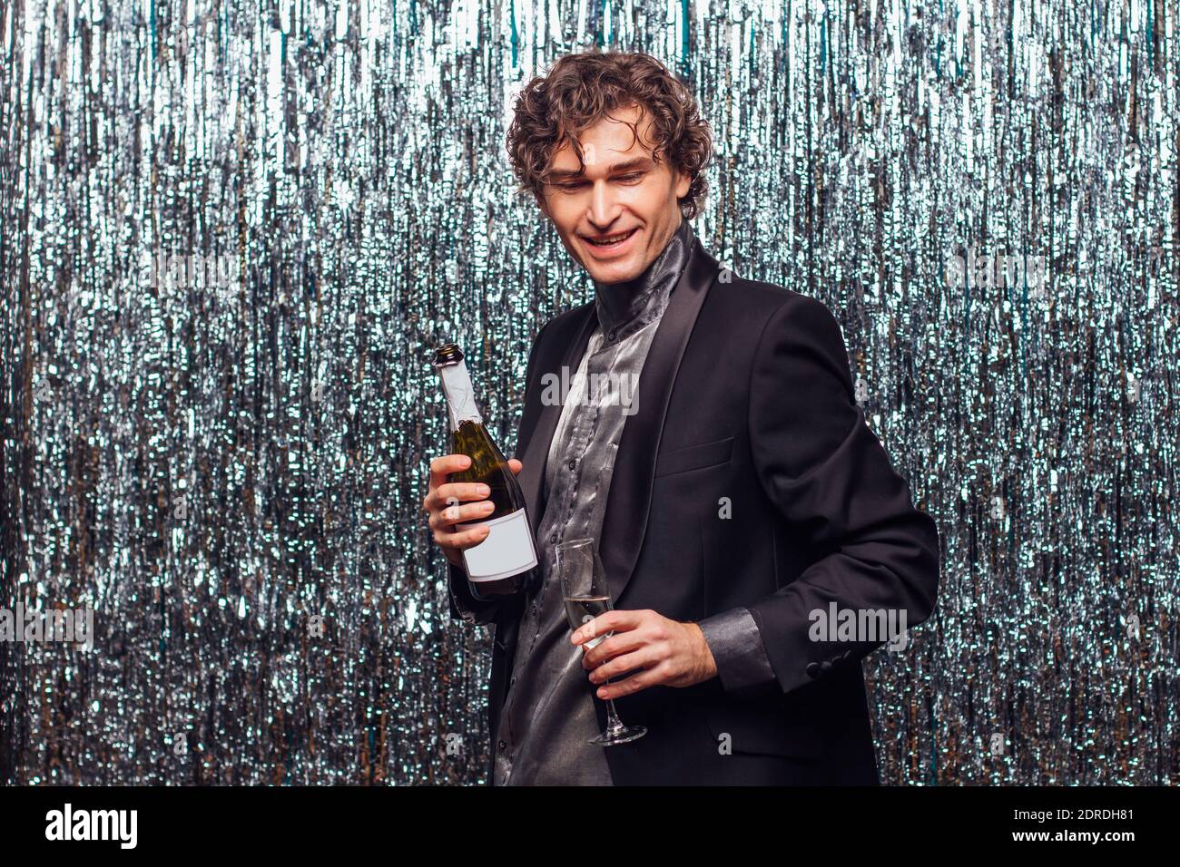 Holidays concept - happy tipsy man with bottle of champagne and wine ...