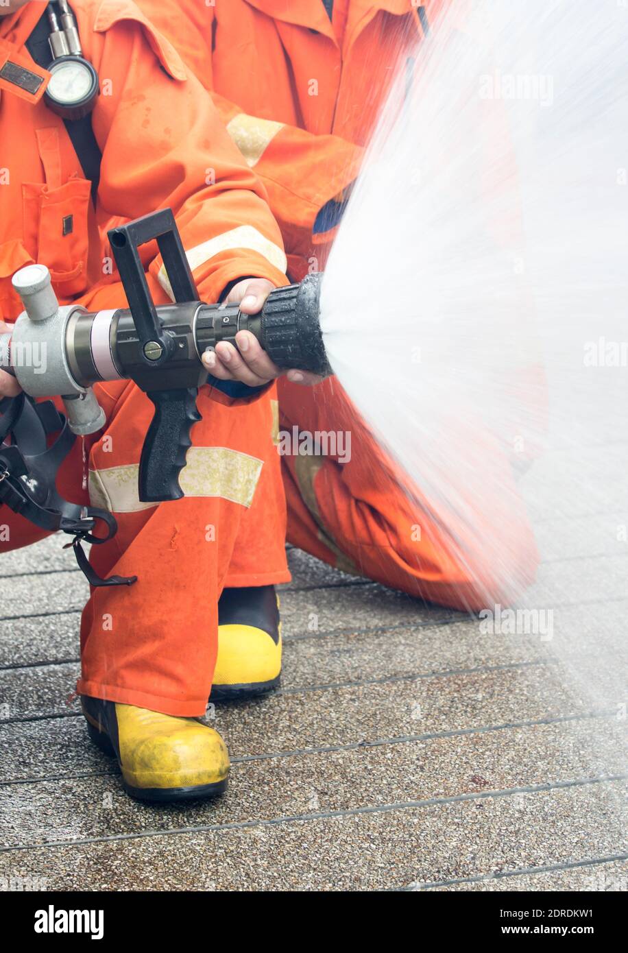 Firefighters spray water Stock Photo - Alamy