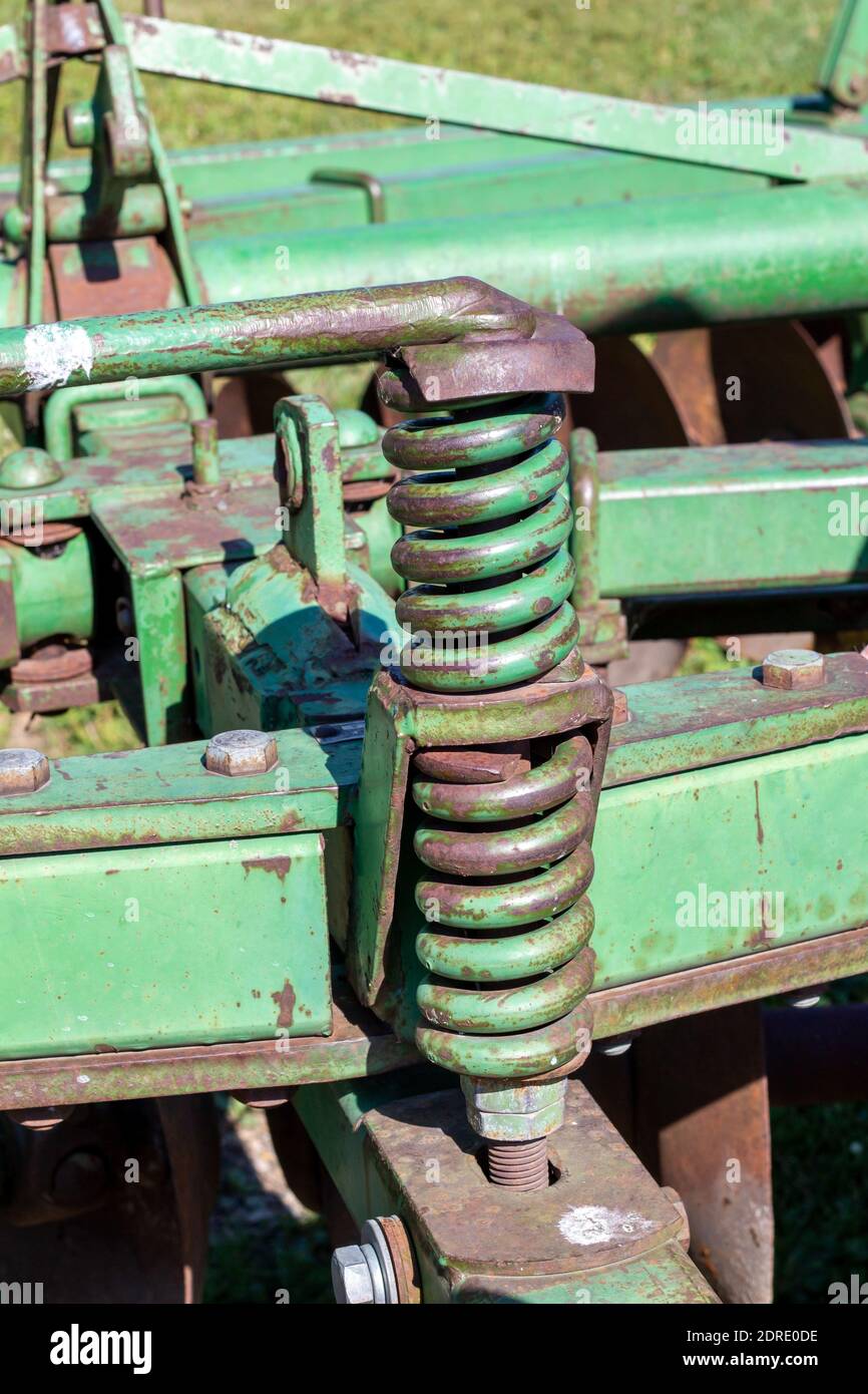 Close up abstract view of a large metal spring on a vintage tractor ...