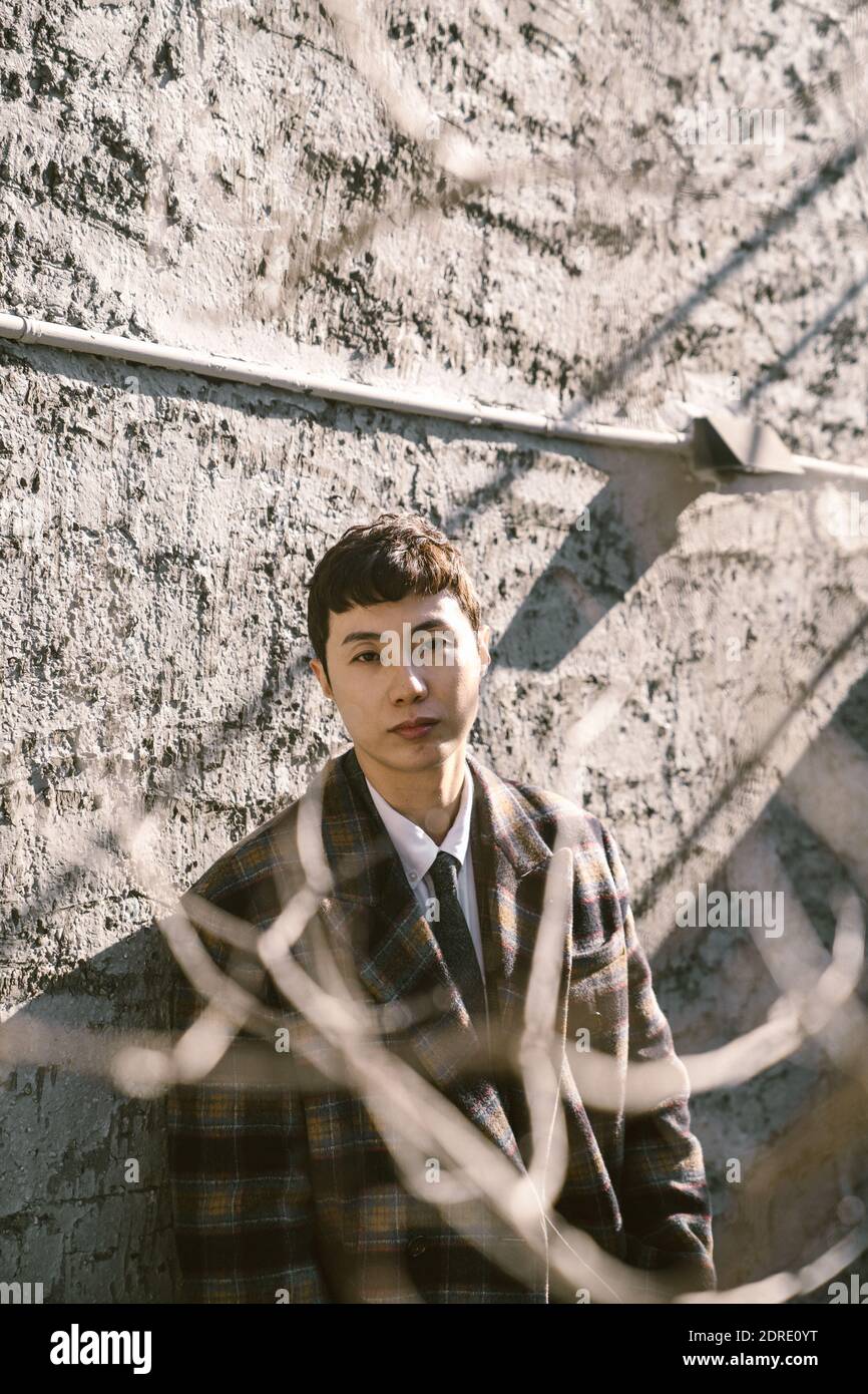 Portrait Of Young Man Standing Against Wall Stock Photo - Alamy