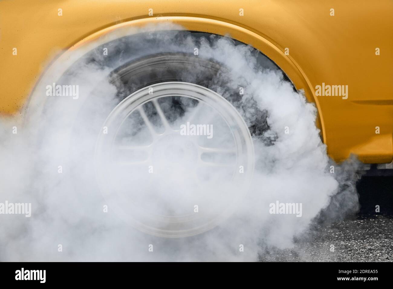 Drag racing car burns rubber off its tires in preparation for the race ...