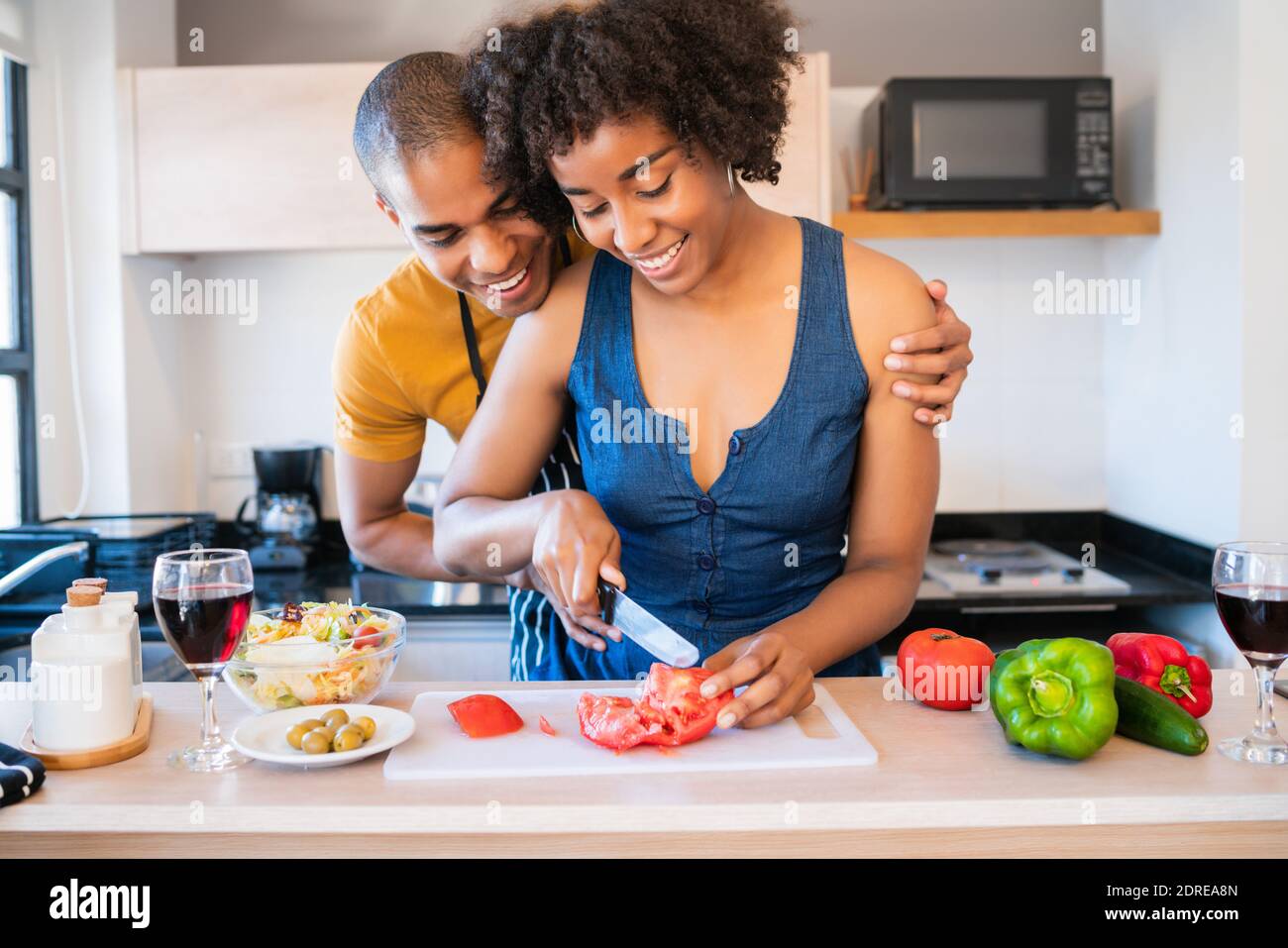 Latin couple cooking together in the kitchen Stock Photo - Alamy