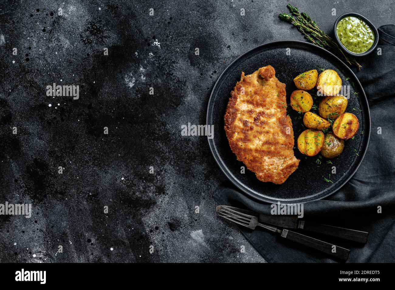 Breaded german weiner schnitzel with potatoes. Black background. Top ...