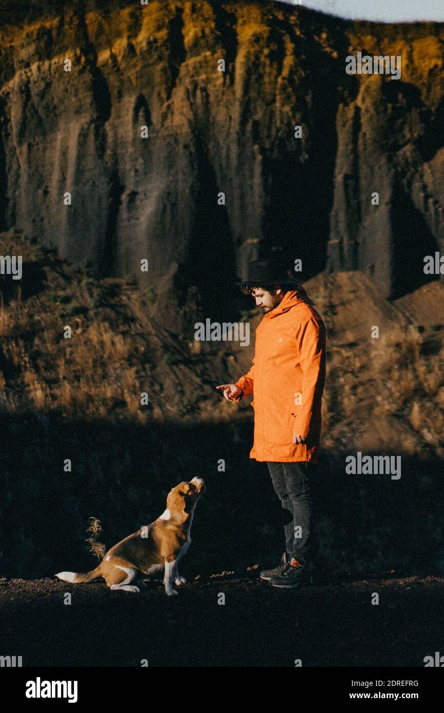 Full Length Of Man Talking With Dog While Standing On Land Stock Photo ...