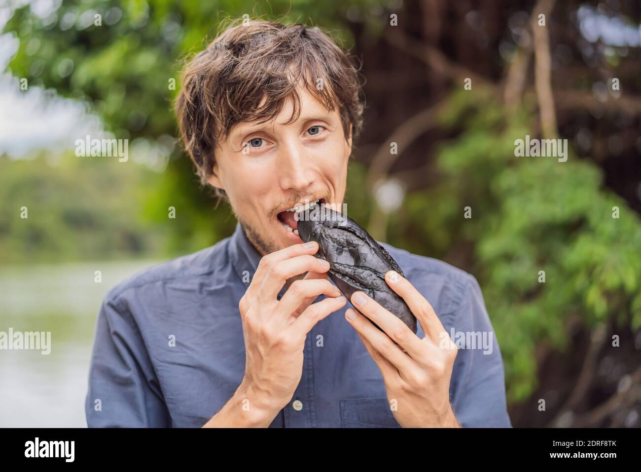 Man eating Vietnamese Pork Banh Mi Sandwich in a black baguette Stock ...