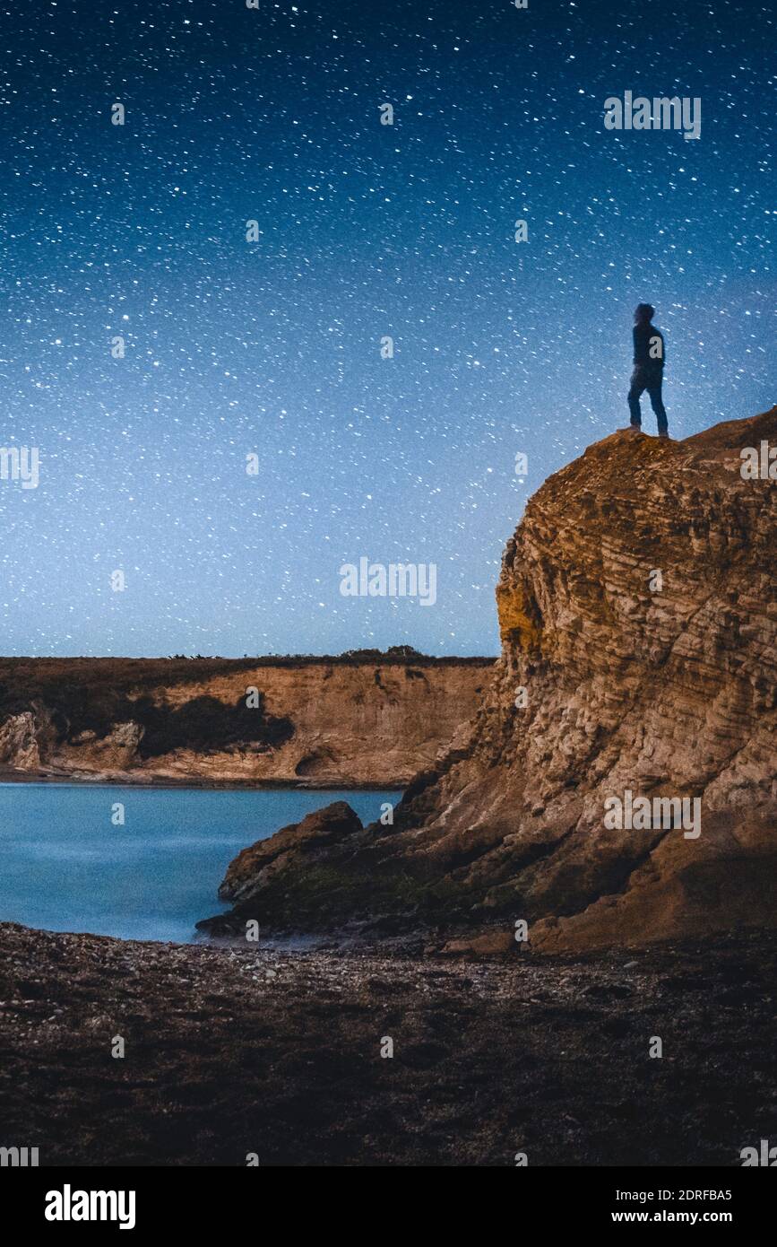 Man standing on cliff night hi-res stock photography and images - Alamy