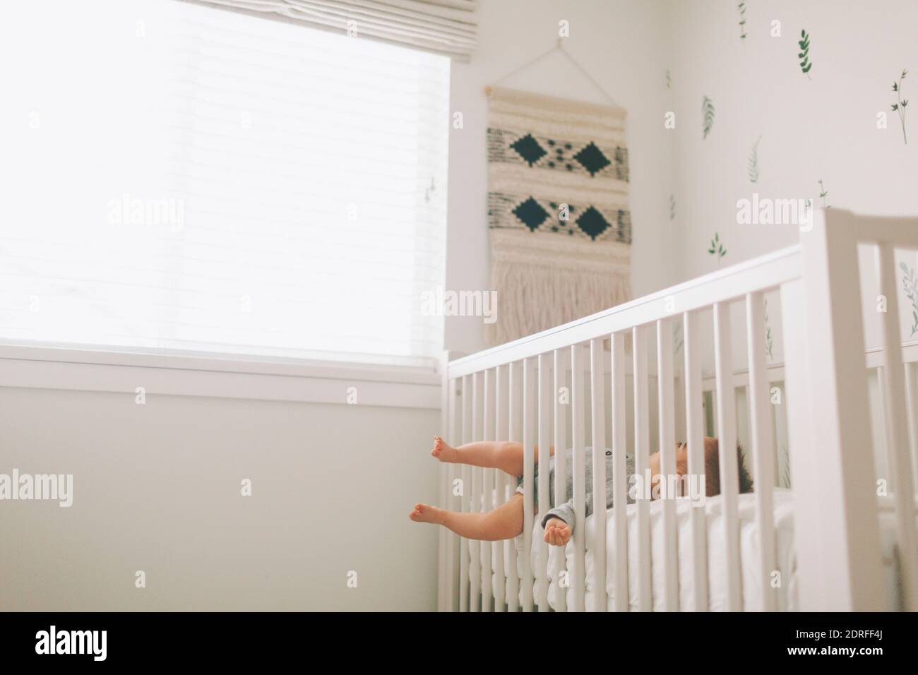 Baby lying leg crib hi-res stock photography and images - Alamy