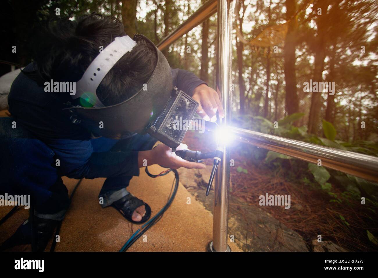 Welders weld metal fences by welding machines Stock Photo - Alamy