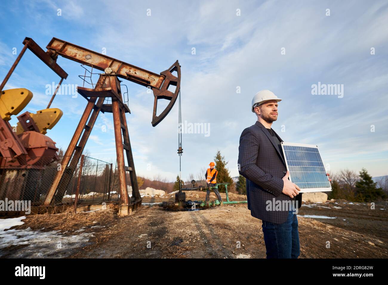 Businessman holding portable solar panel while operator working on ...