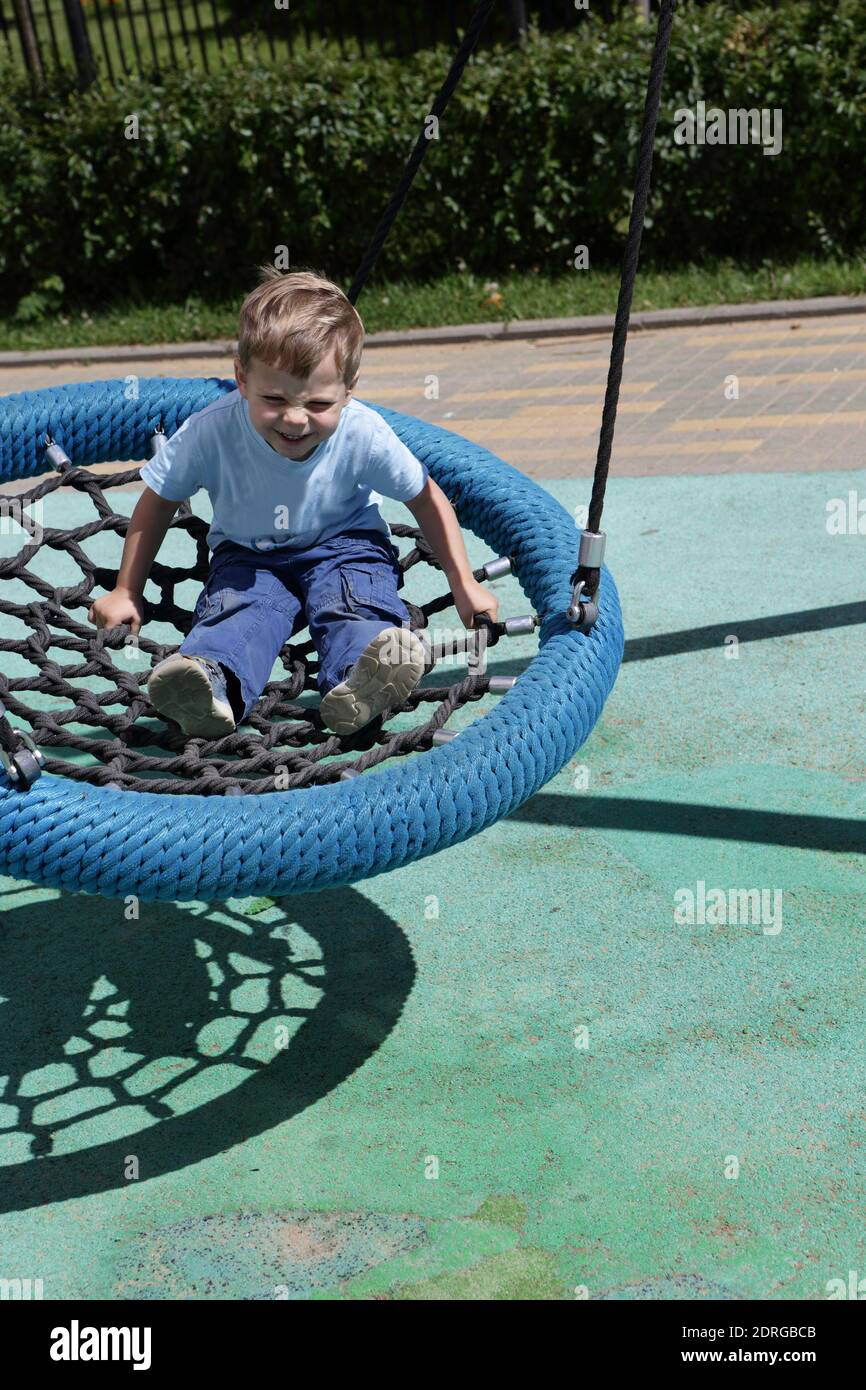 Child sitting on swing at outdoor playground Stock Photo - Alamy