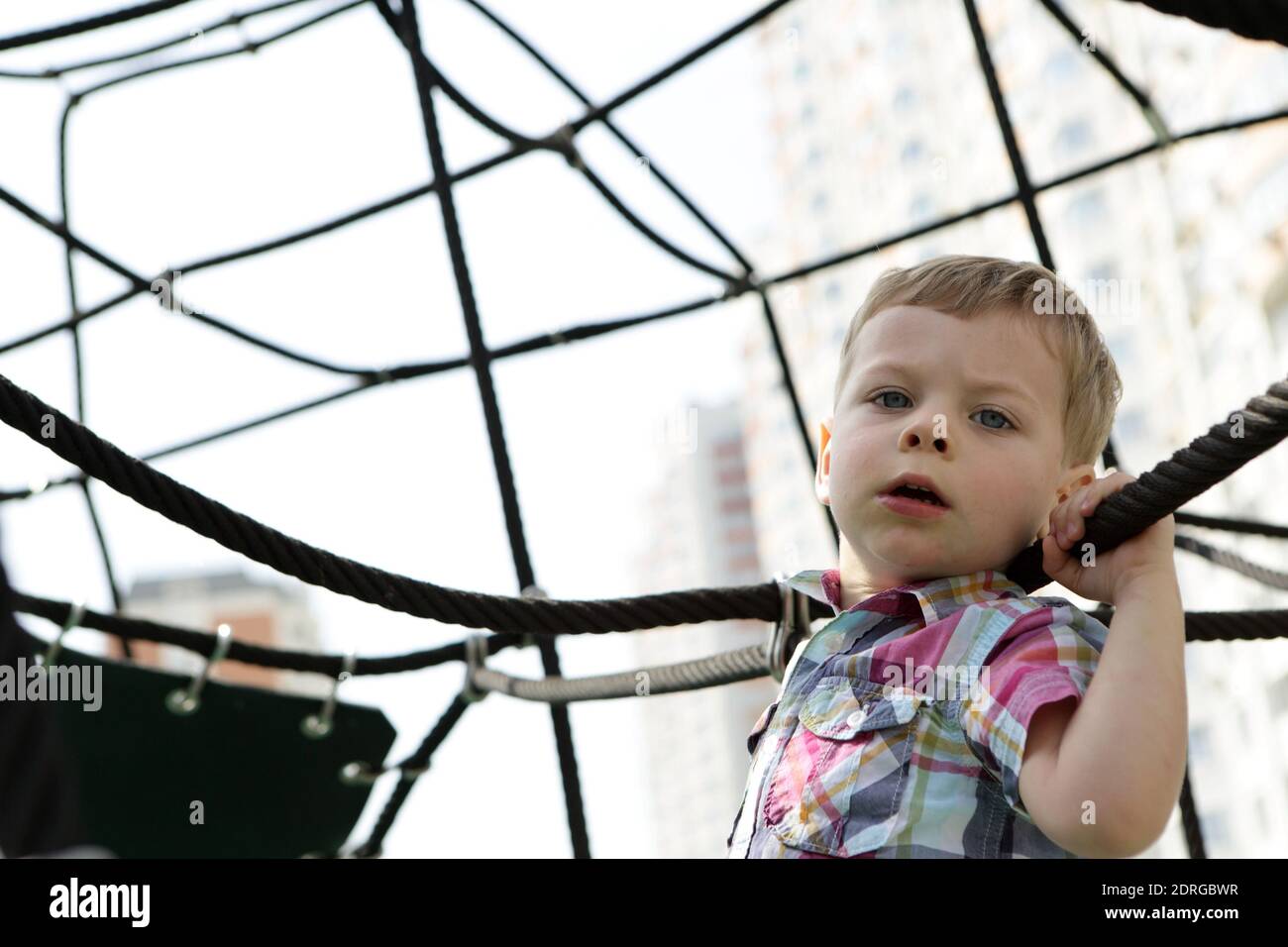 Portrait of a child on climbing net Stock Photo - Alamy