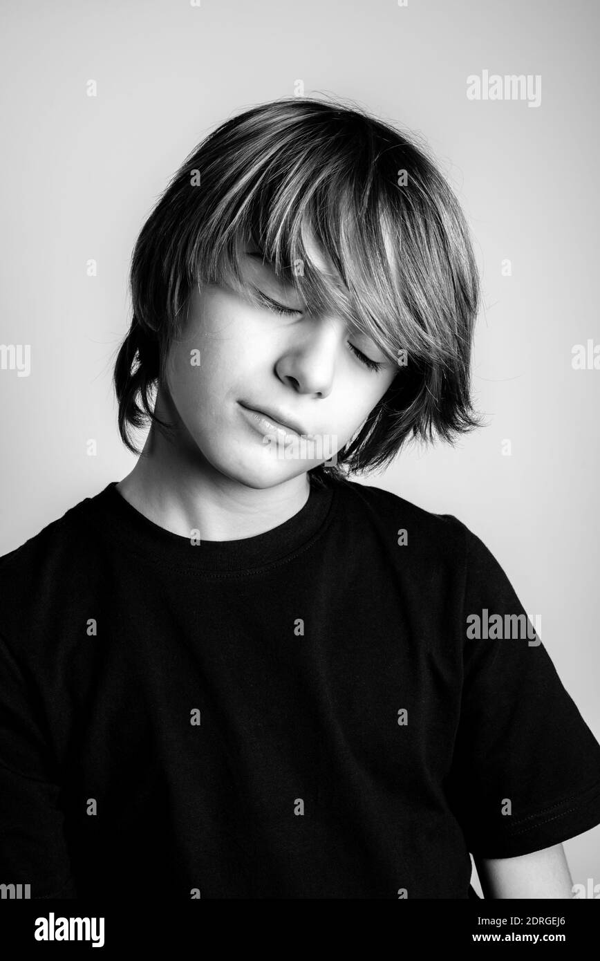 Cute Boy With Eyes Closed Against White Background Stock Photo - Alamy