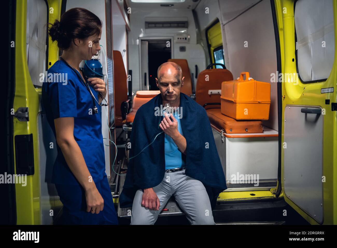 An EMT taking care of a man rescued from the fire Stock Photo - Alamy