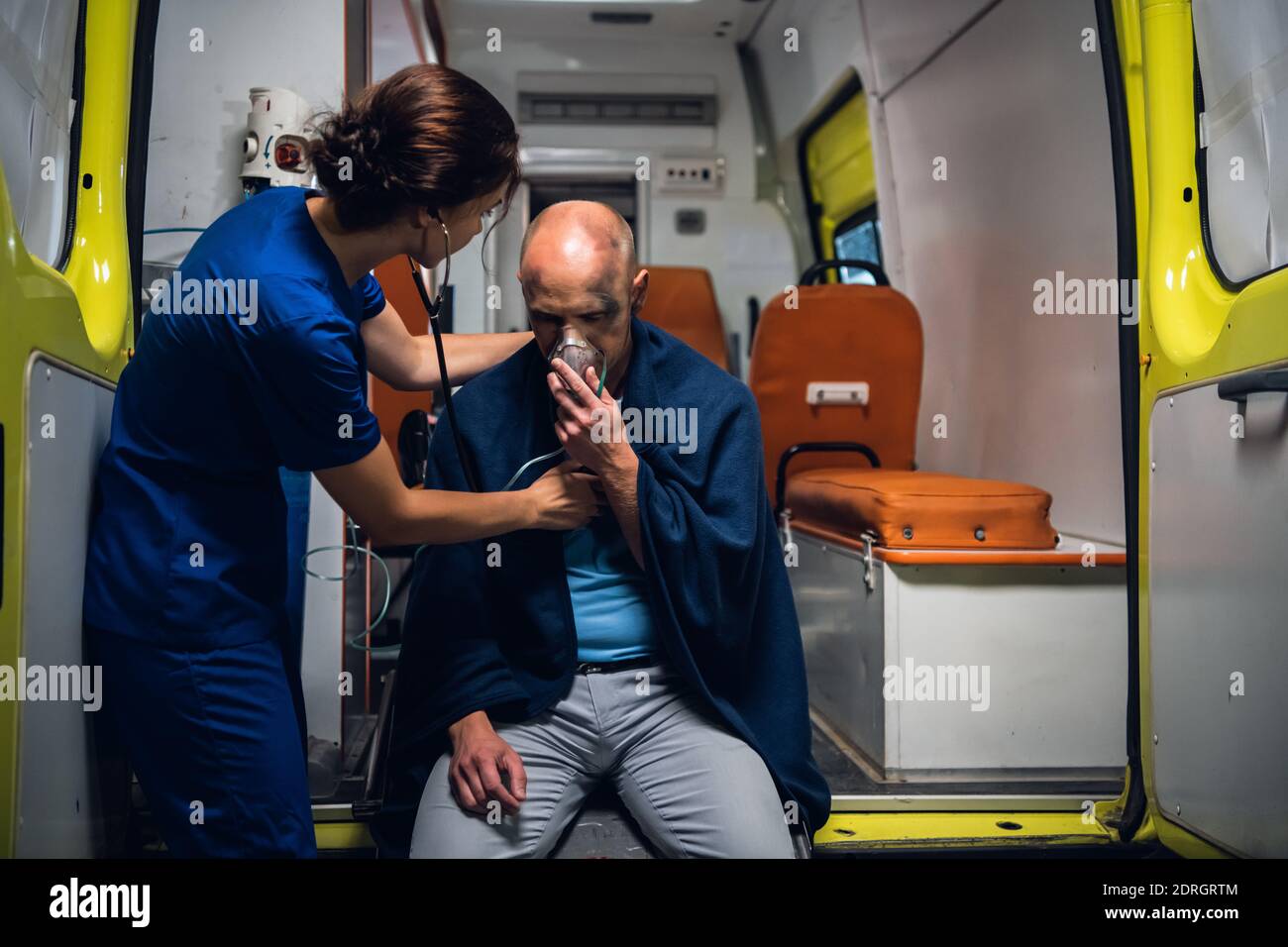 A female paramedic with a stethoscope is checking her patient's ...