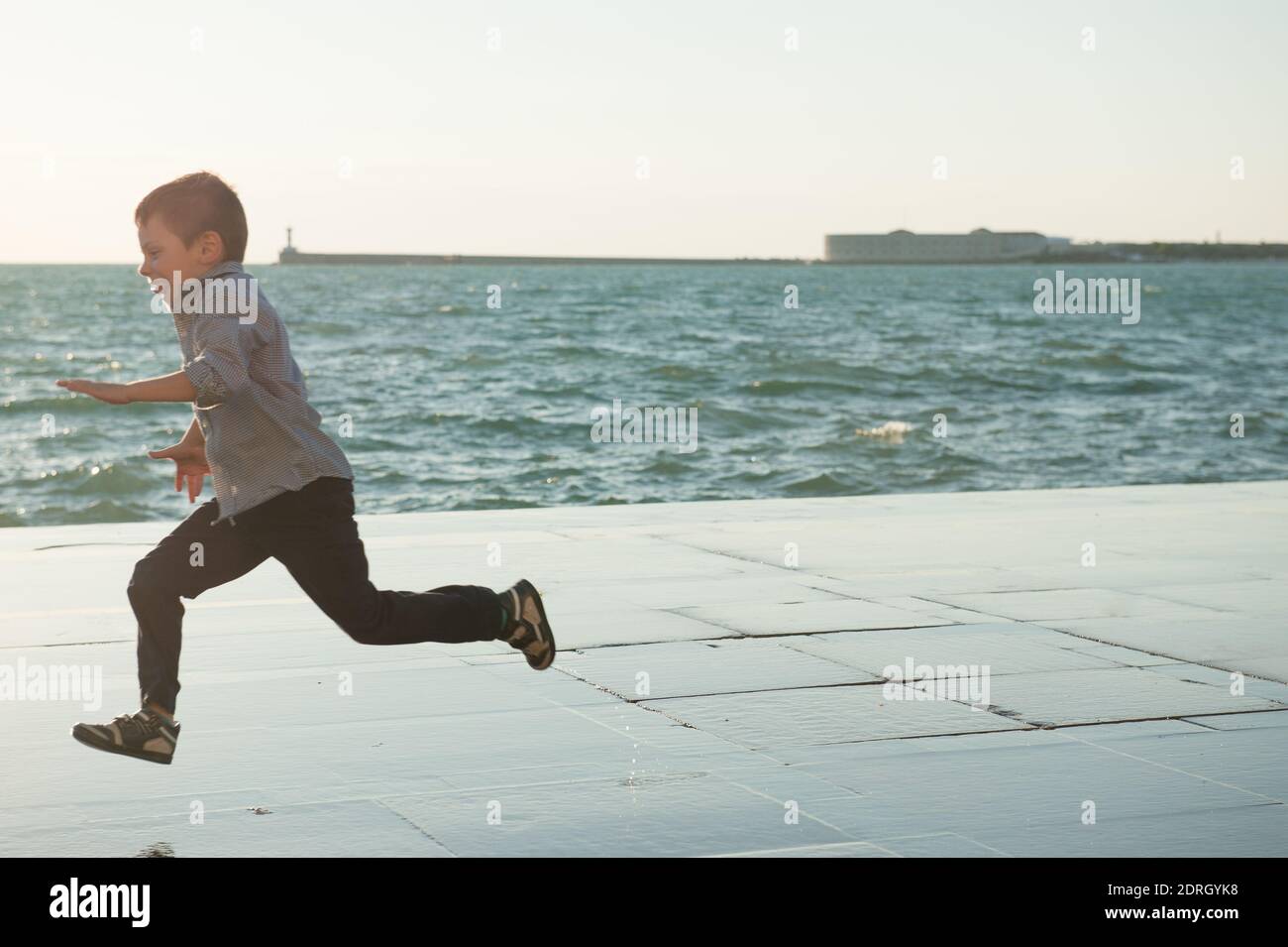 fast escape leisure concept of little boy running away on sea shore in ...