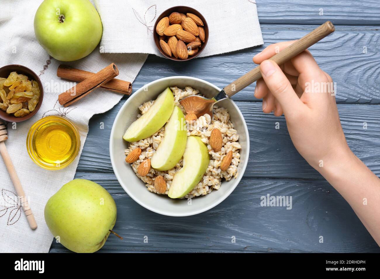 Woman eating tasty oatmeal at wooden table Stock Photo - Alamy