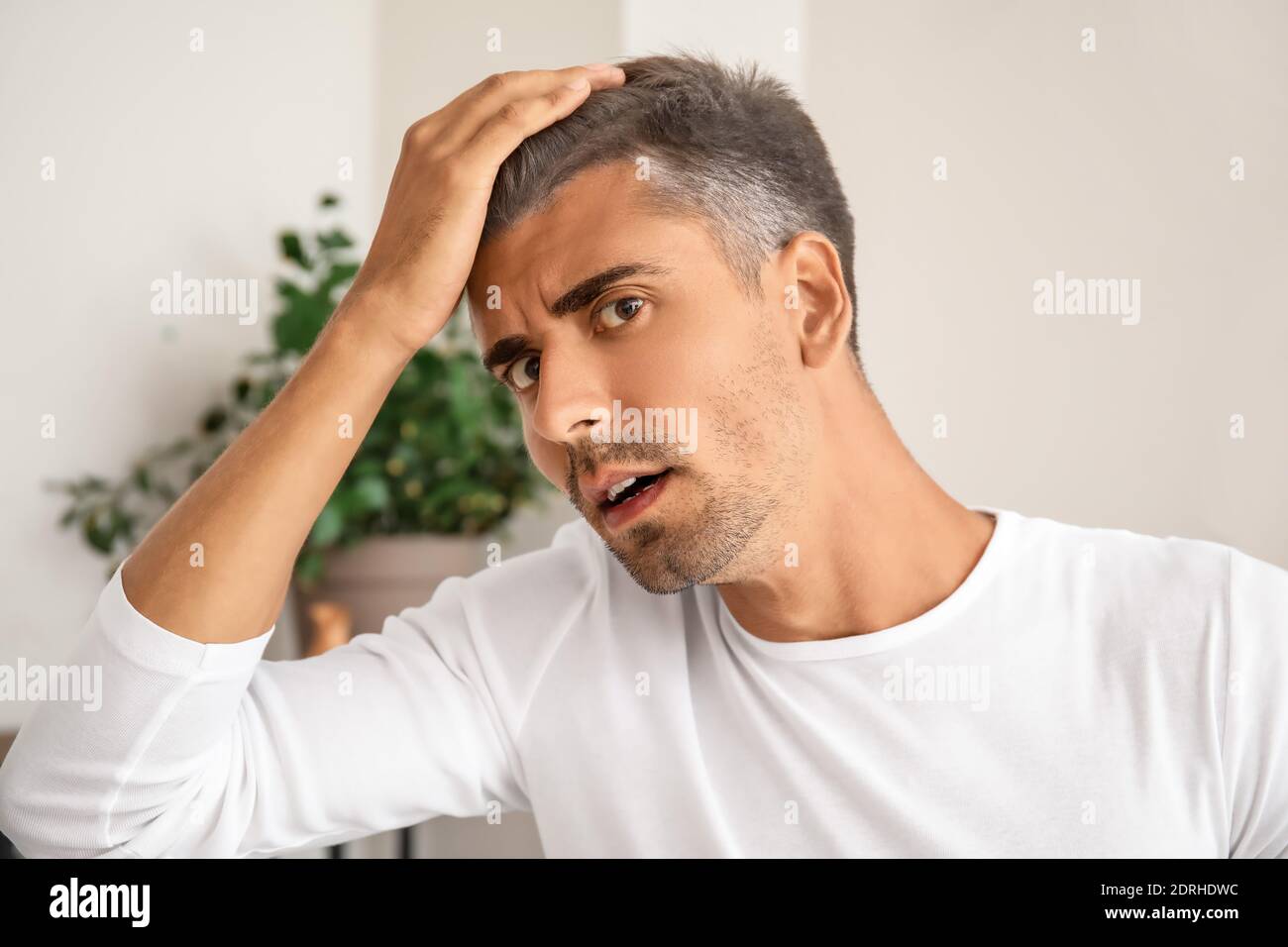 Stressed man with graying hair at home Stock Photo - Alamy