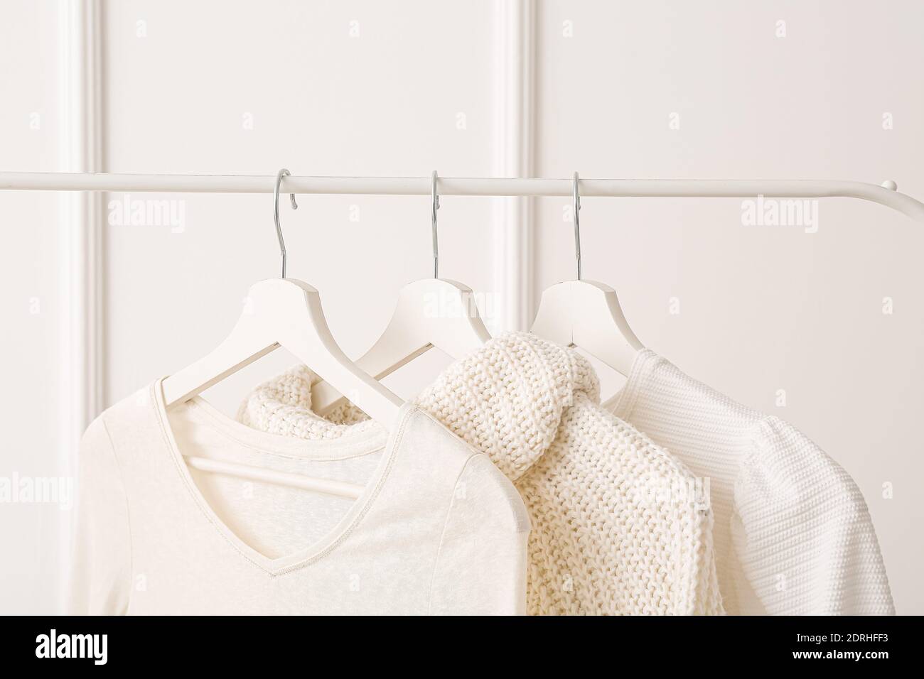 Rack with clothes on white background Stock Photo - Alamy