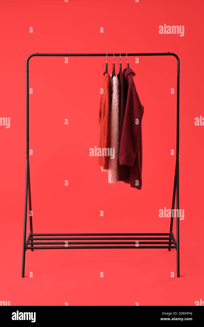 Rack with clothes on color background Stock Photo - Alamy