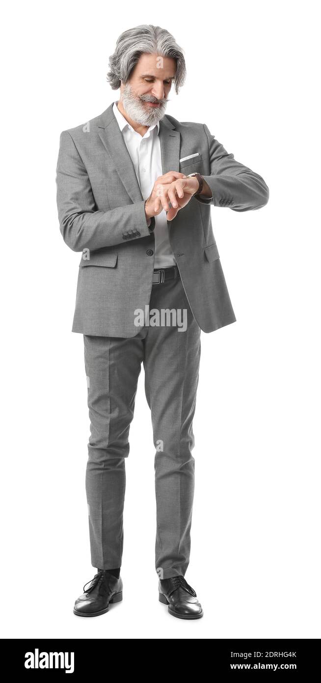Portrait of senior businessman looking at his watch on white background ...