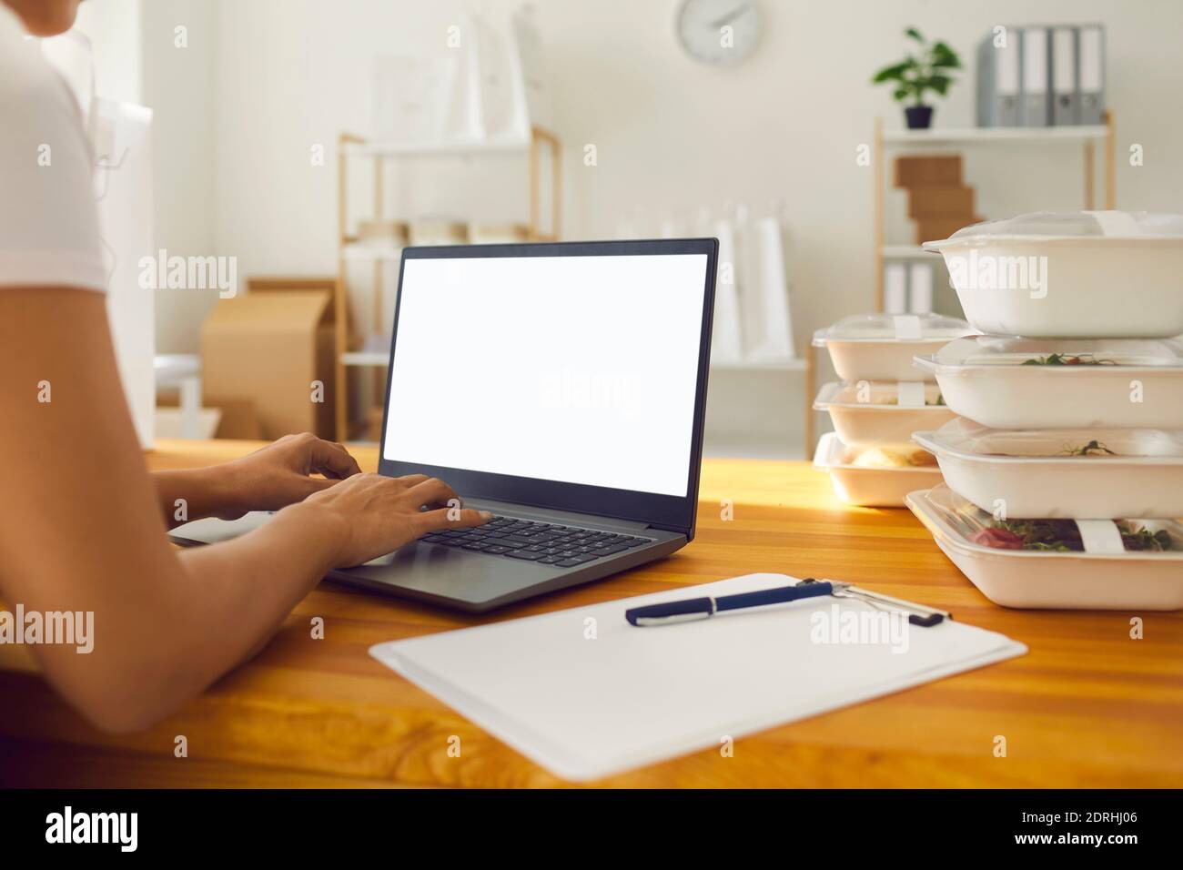 Meal delivery worker using laptop with blank screen to process orders ...