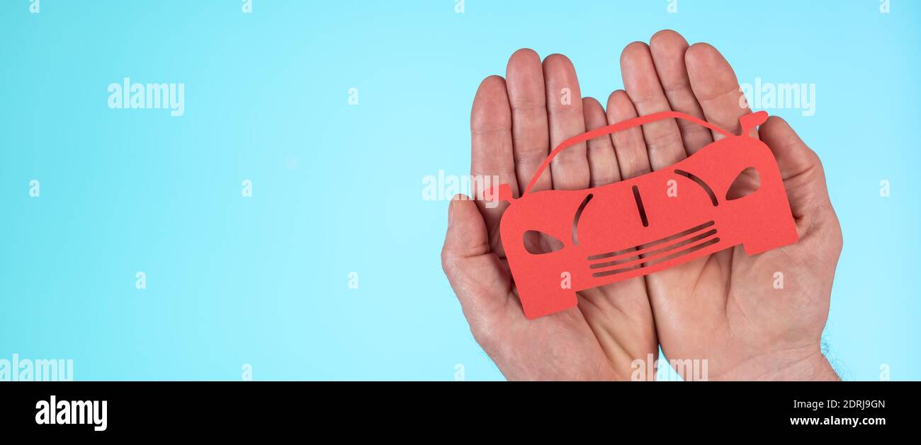 Concept of sports car insurance with paper sports car in hands on light ...