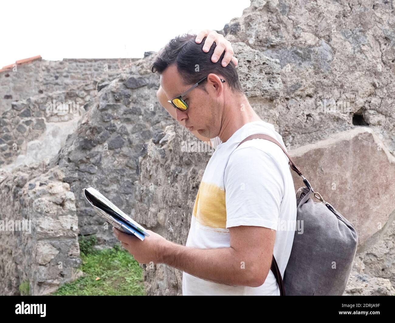 Confused traveler backpacker man exploring ancient ruins while checking ...