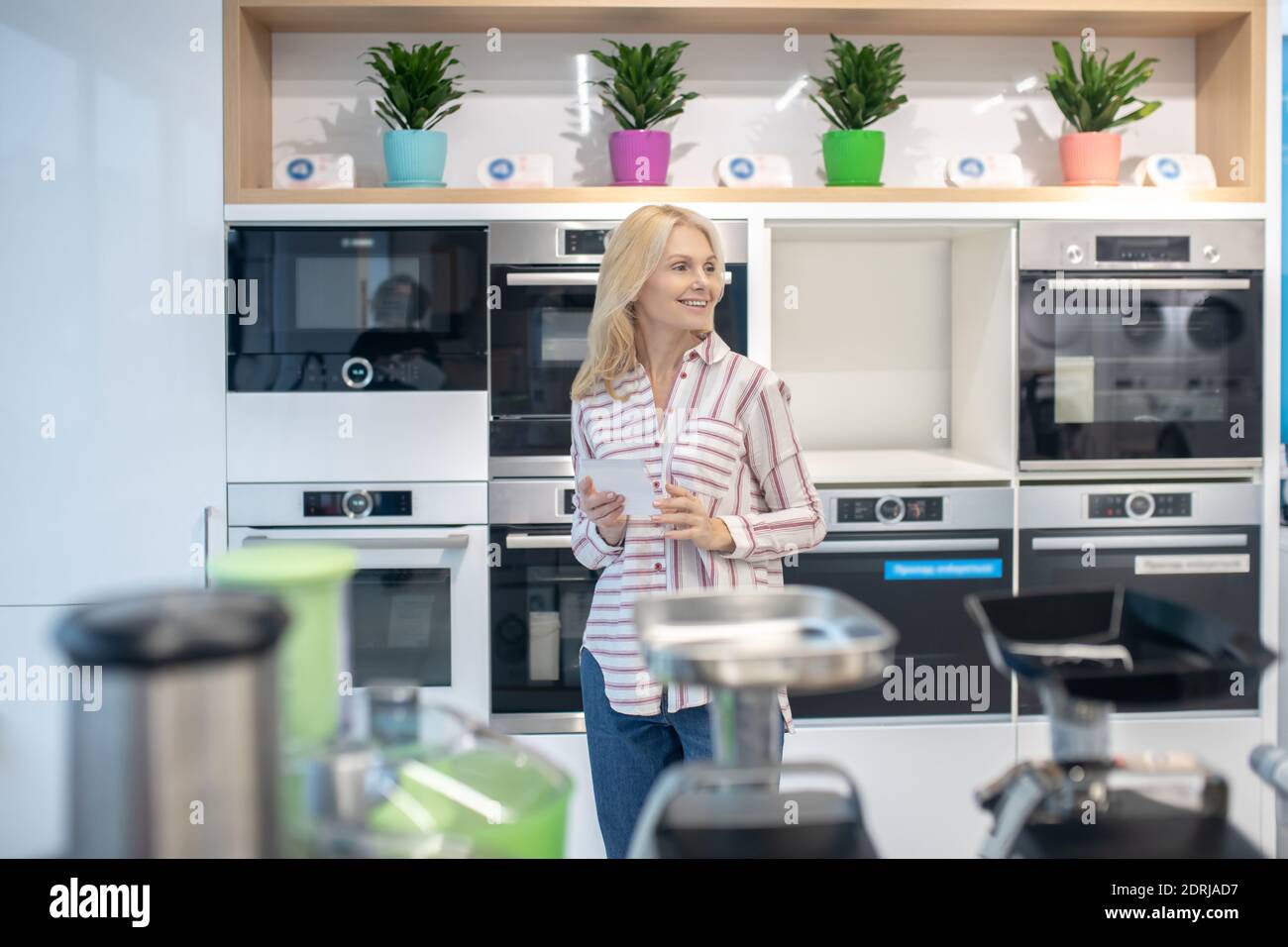 Blonde pretty customer choosing goods in a showroom Stock Photo - Alamy