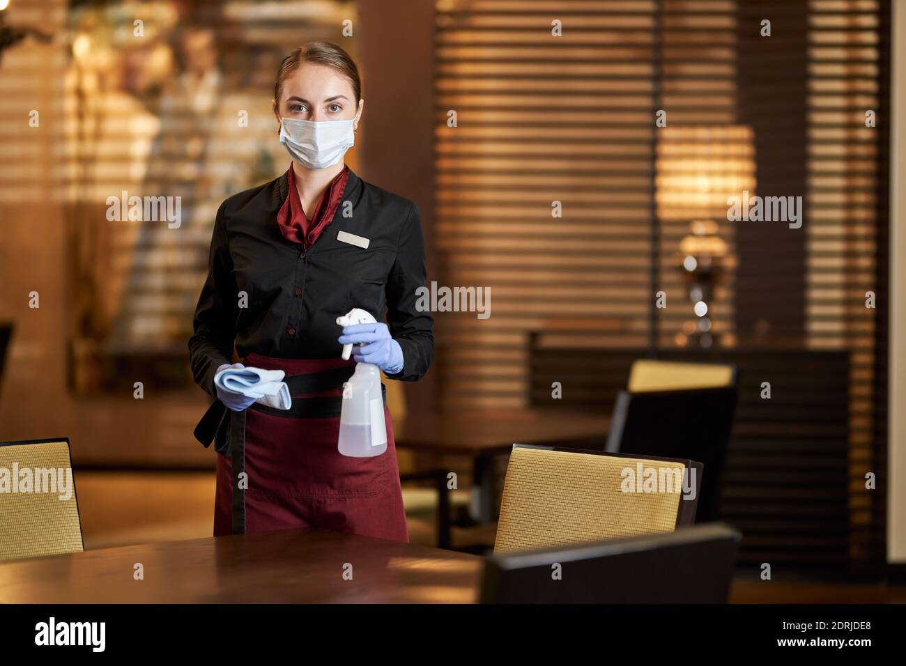 Copy-space photo of an elegant waitress wearing mask and gloves while ...