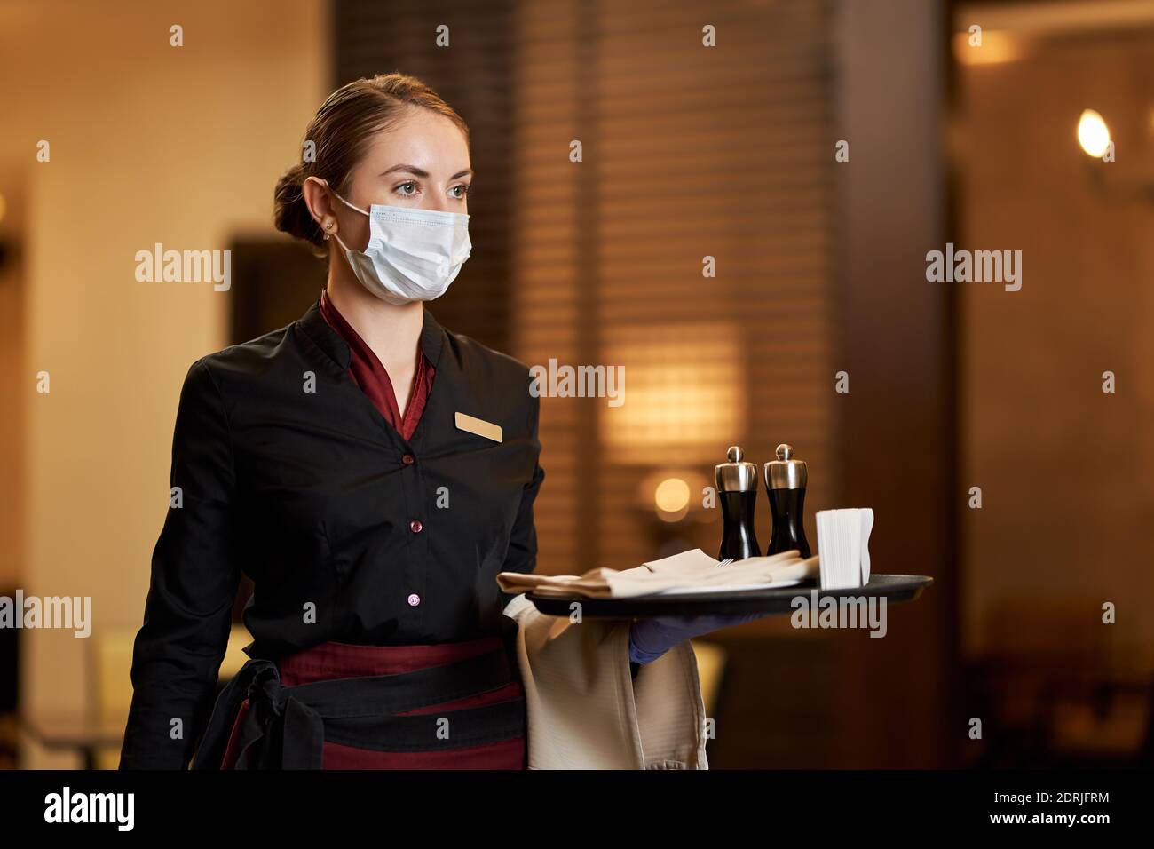 Copy space photo of a good-looking waitress wearing mask while carrying ...