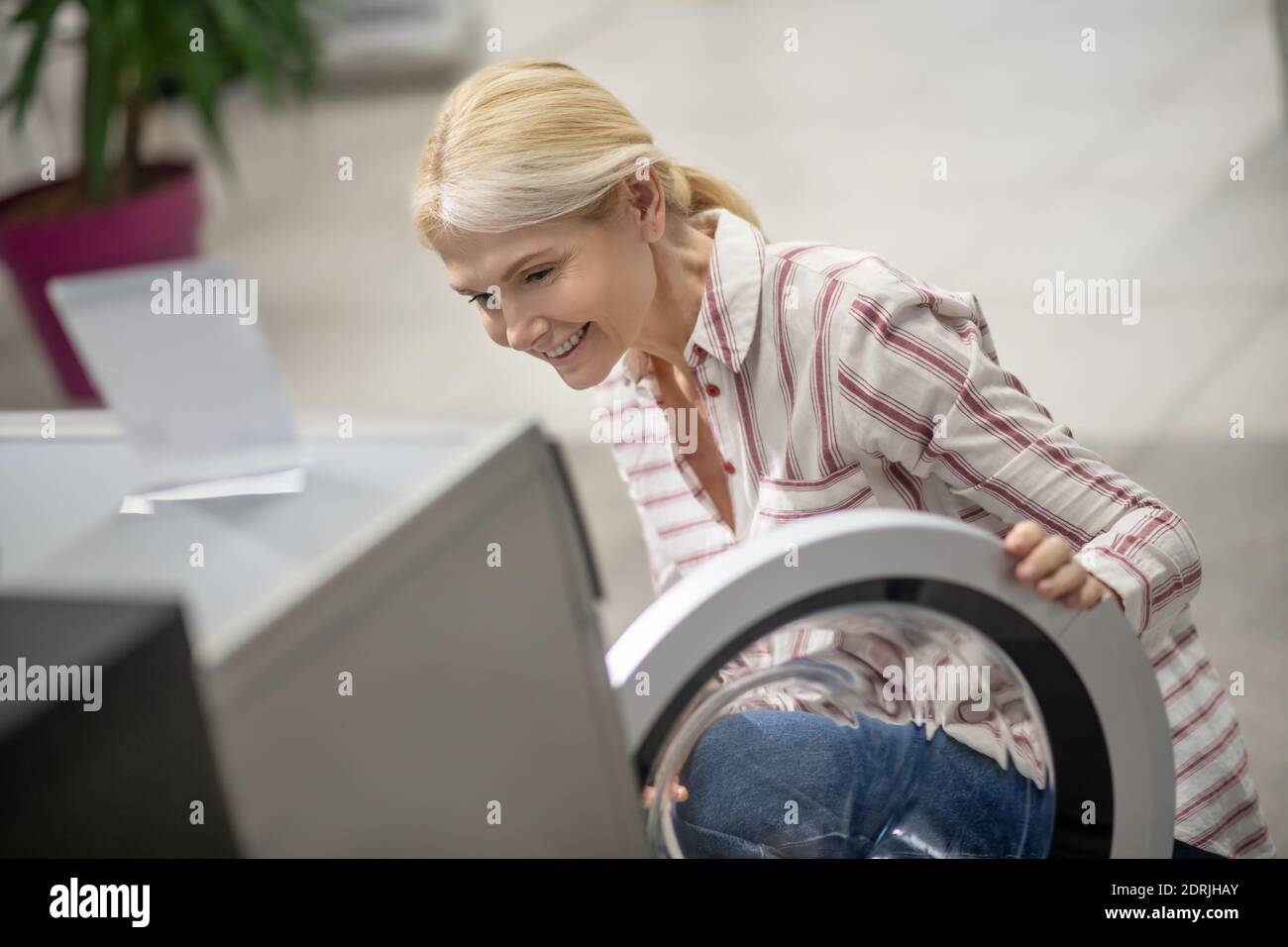 Woman choosing a washing machine in a showroom Stock Photo - Alamy