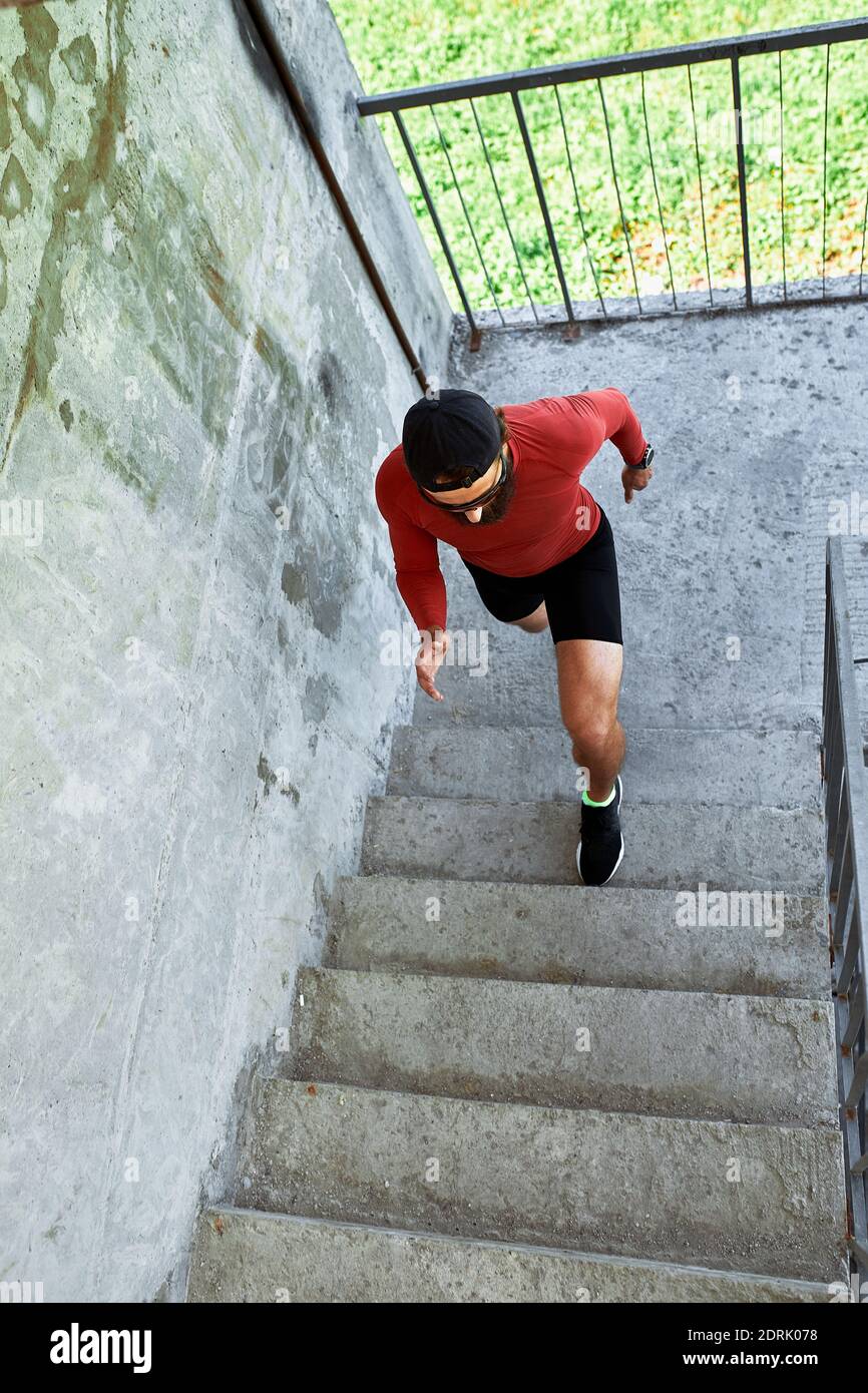 Concentrated male athlete running up stairs to make training more ...