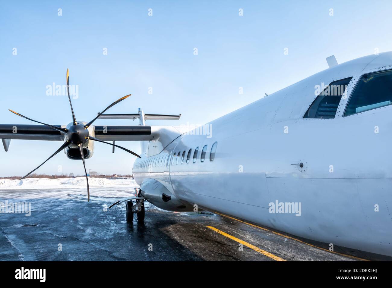 A close-up of the fuselage of a white passenger turboprop airplane on ...