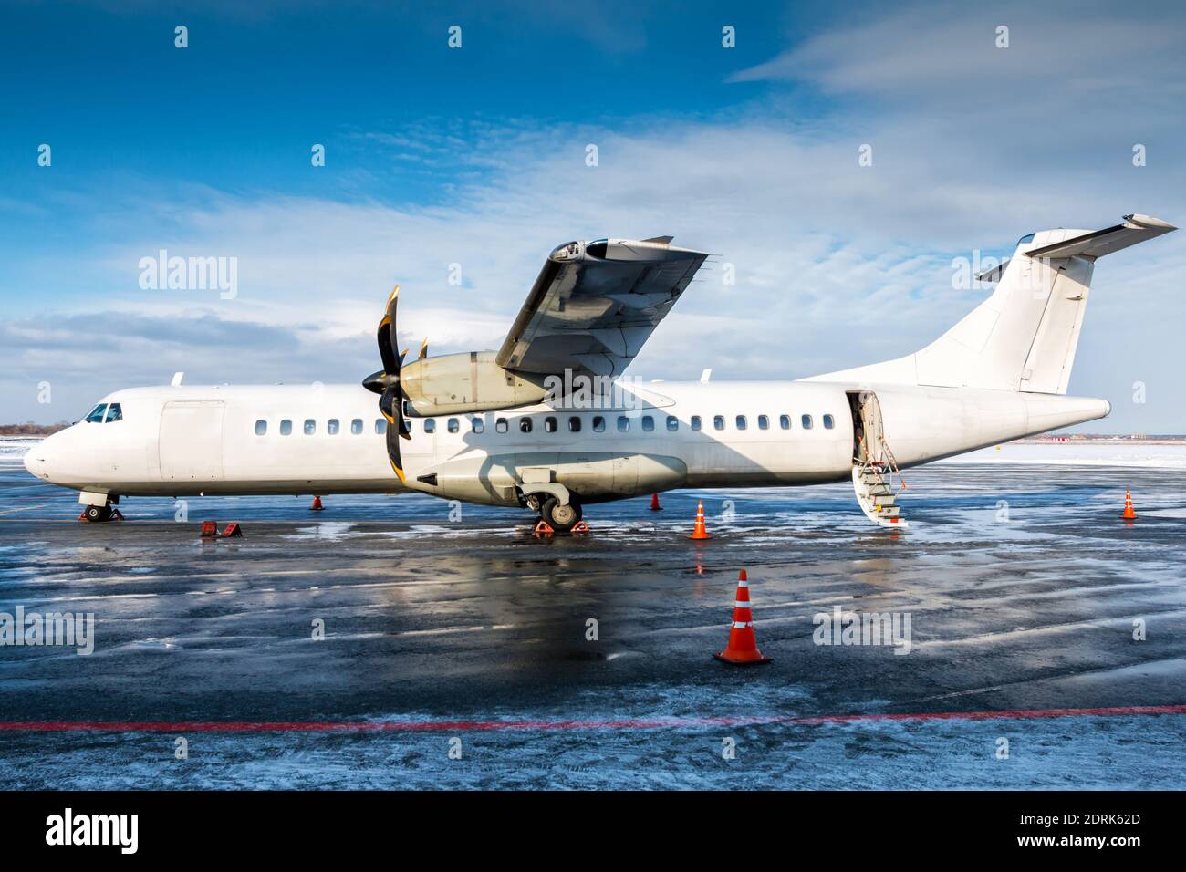 White passenger turboprop aircraft on the apron of the airport with an ...