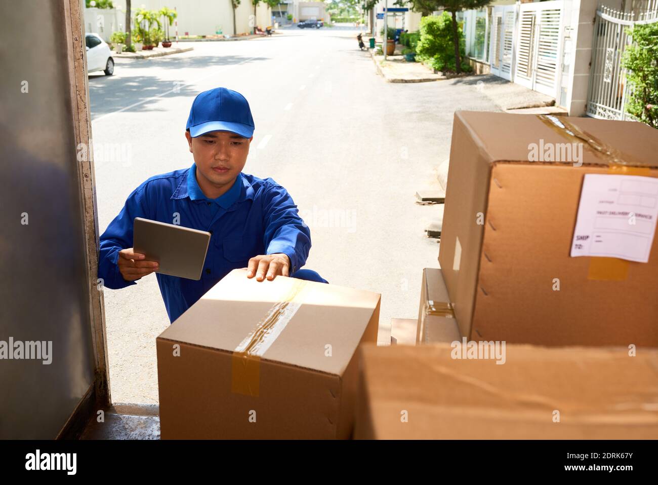 Delivery service worker loading truck Stock Photo - Alamy