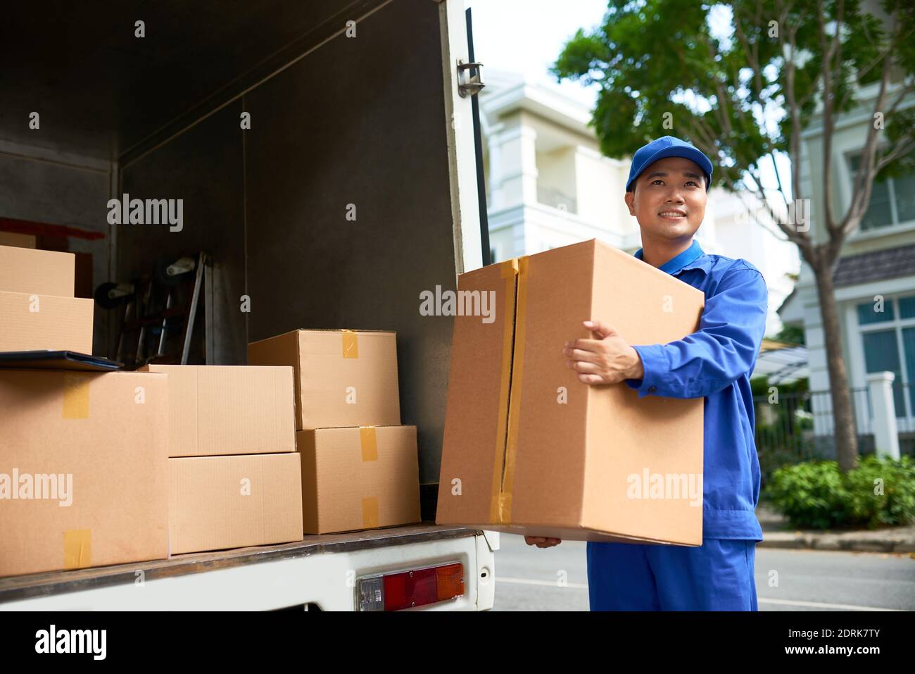 Courier with cardboard box Stock Photo - Alamy