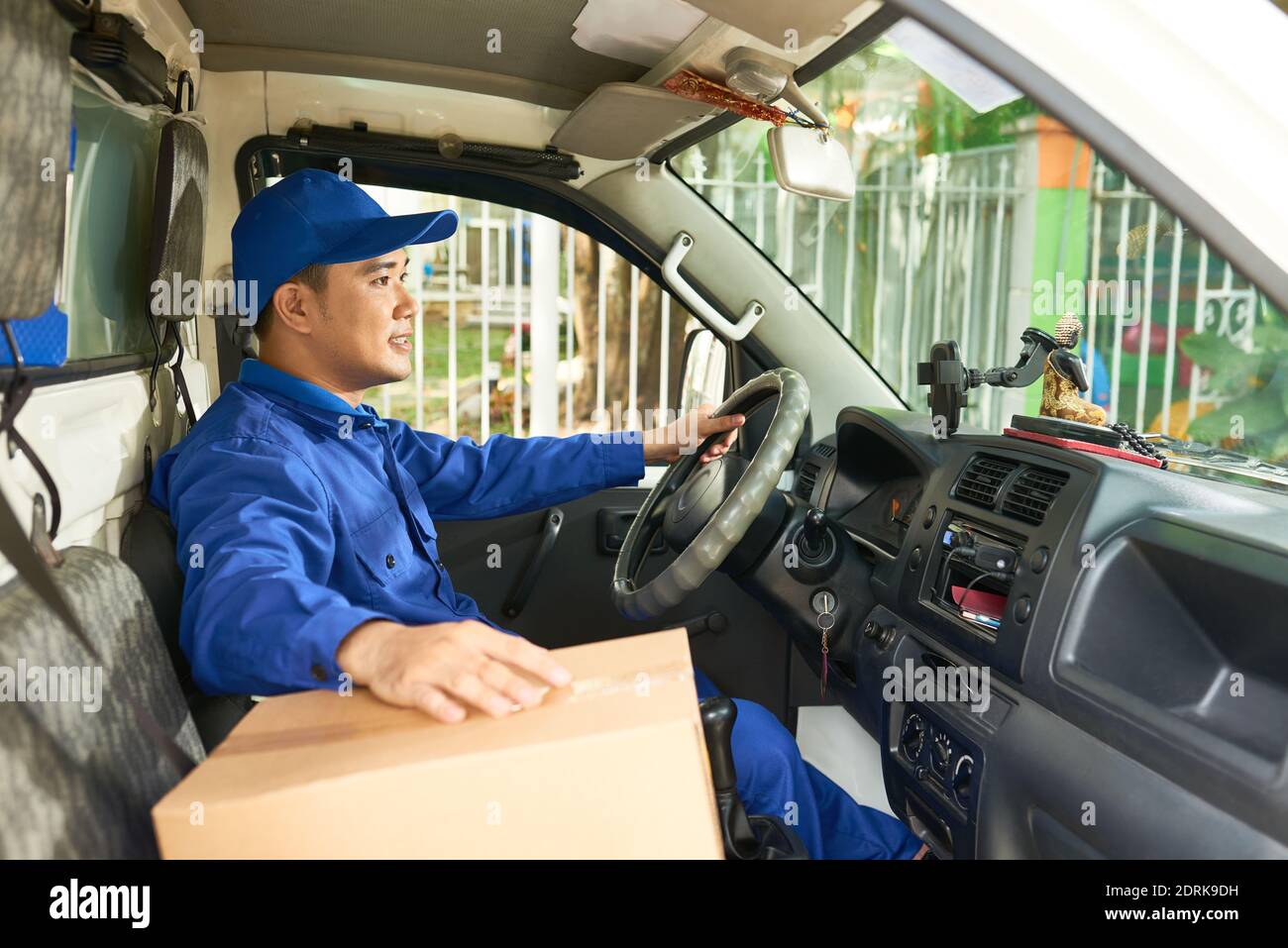Courier driving delivery truck Stock Photo - Alamy