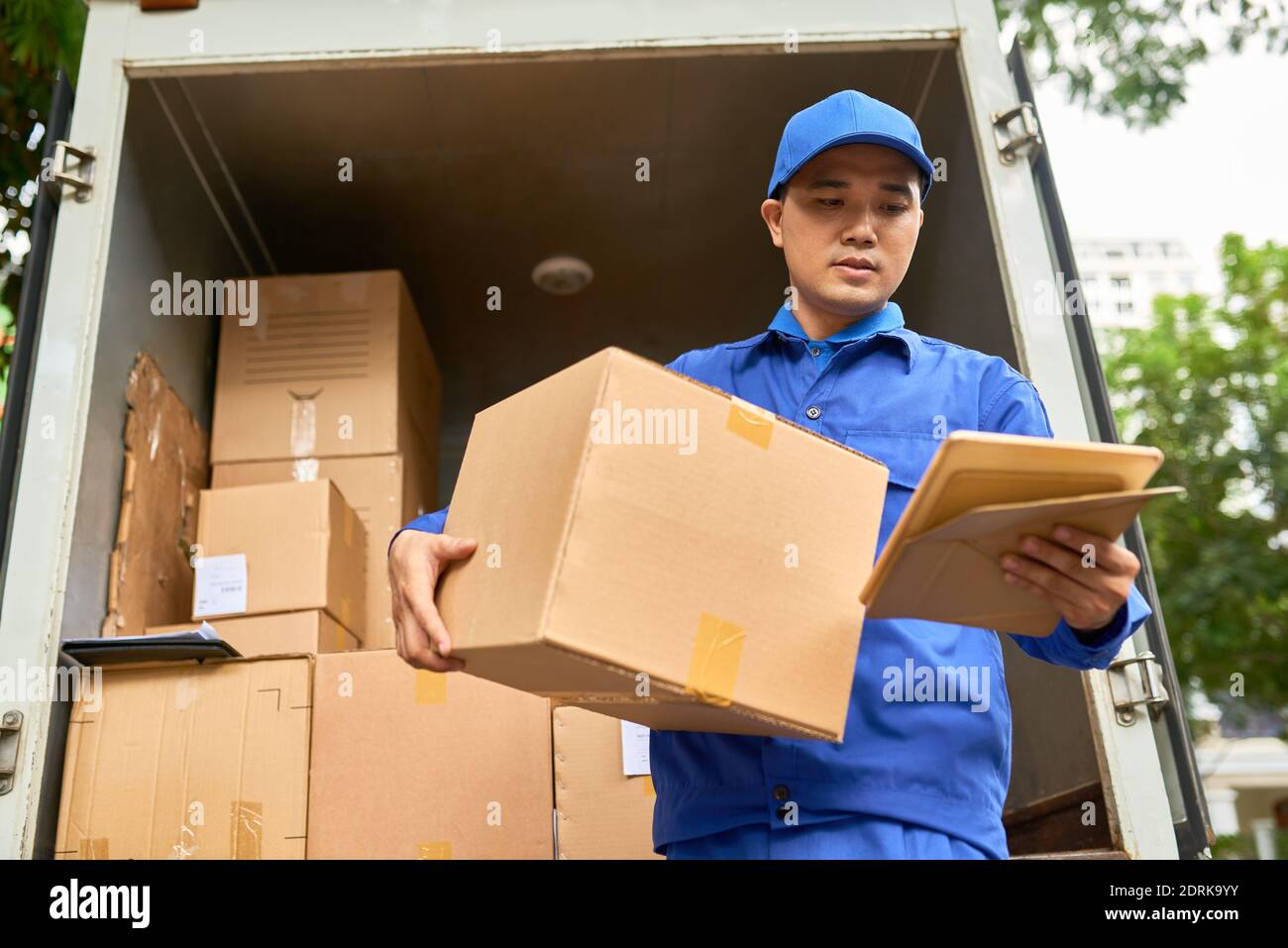 Courier carrying package to customer Stock Photo - Alamy