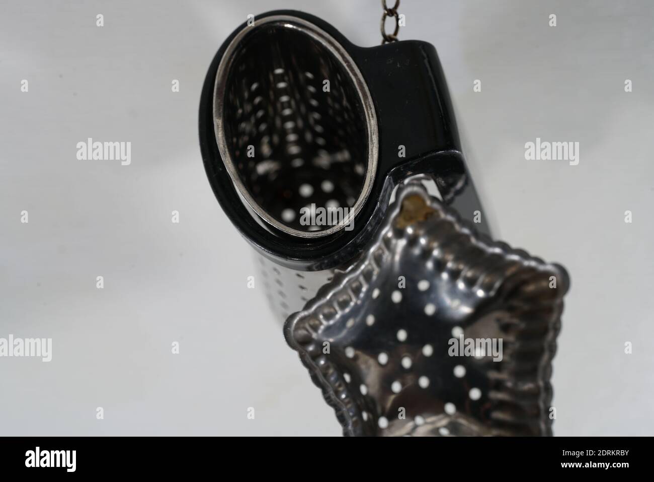 A top view closeup of a etal tea strainer hung up to dry in the kitchen ...