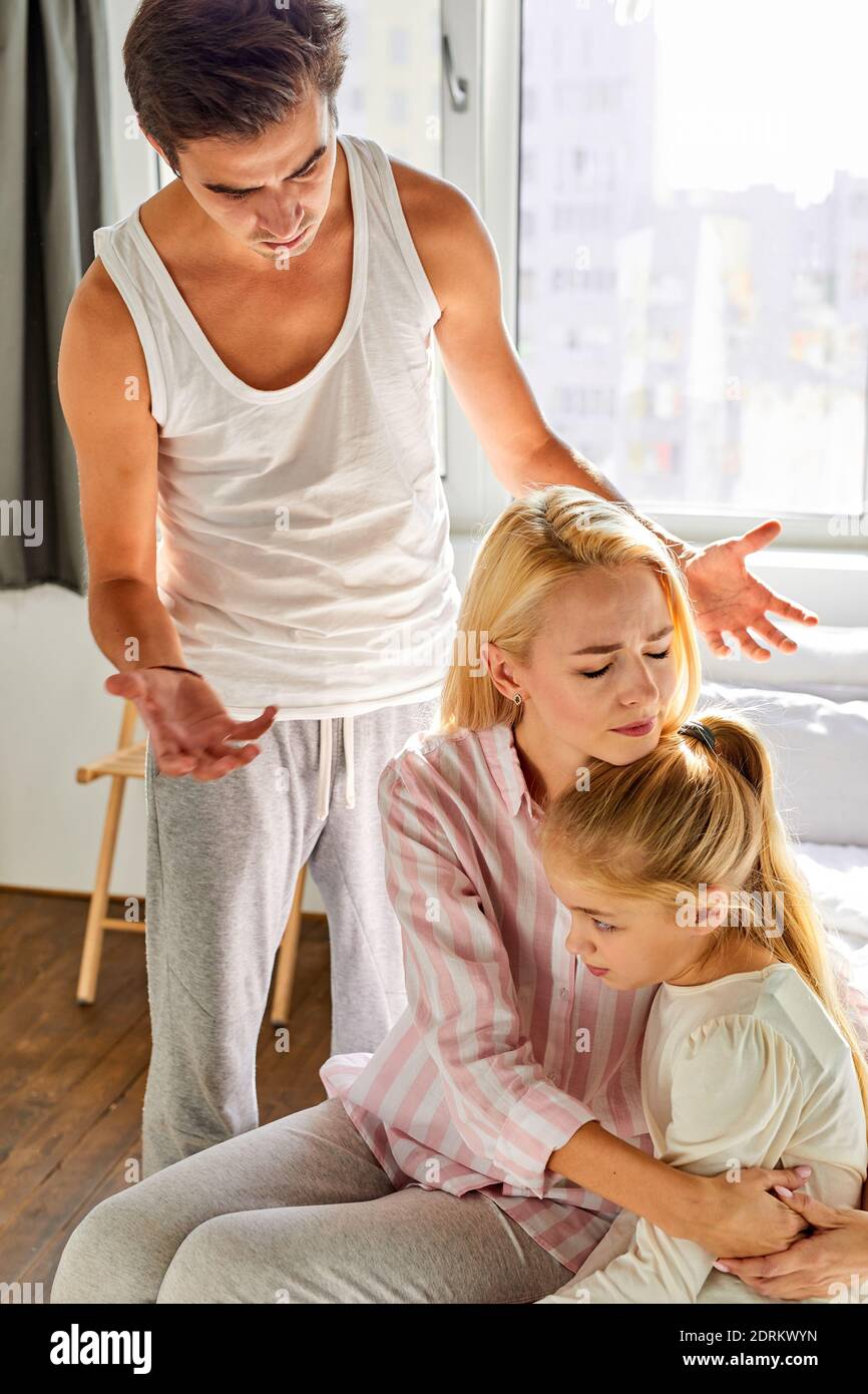 angry father scolds daughter and wife, family problems. scared child ...