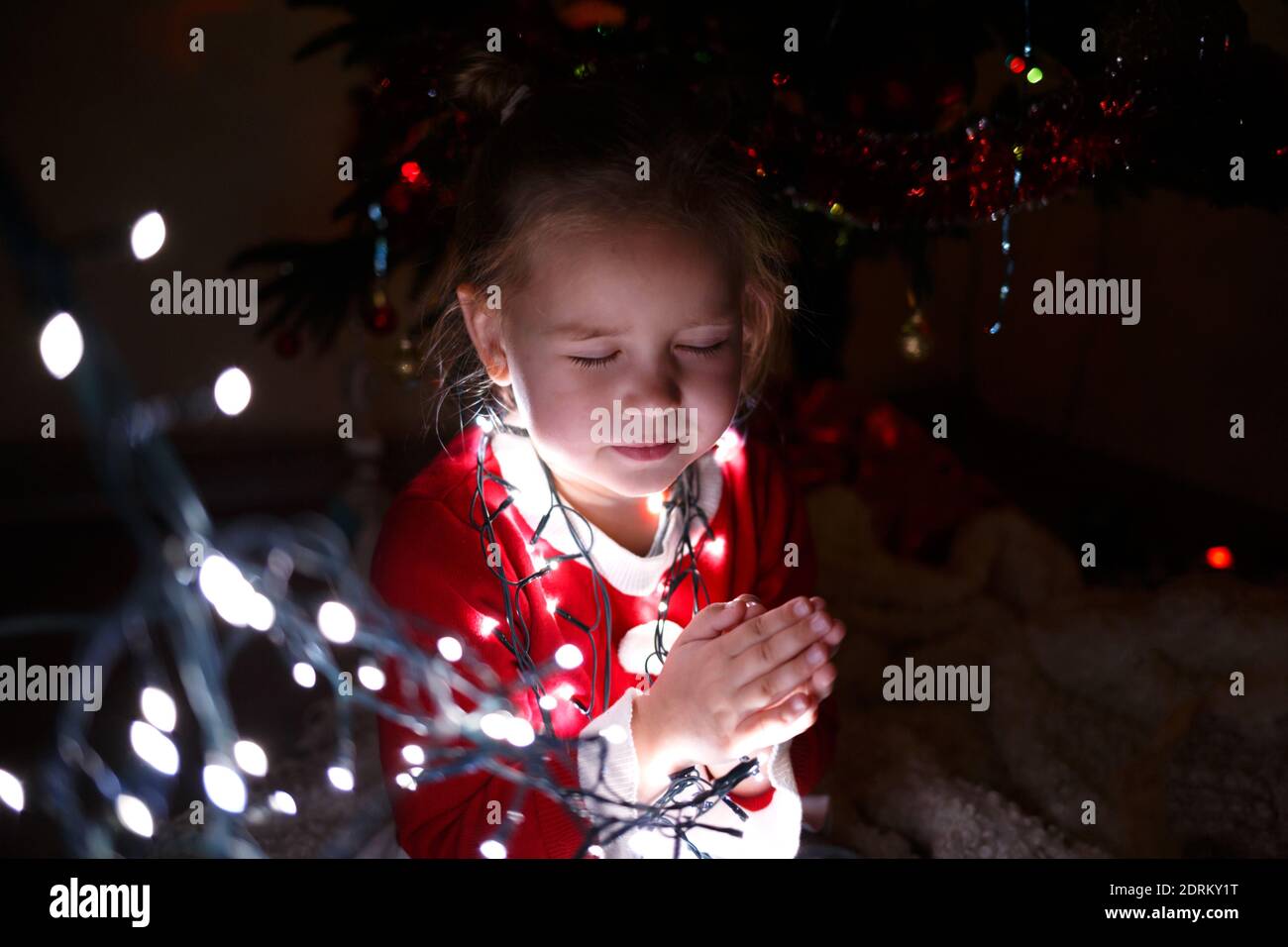 Little cute girl waiting for gifts under the christmas tree Stock Photo ...