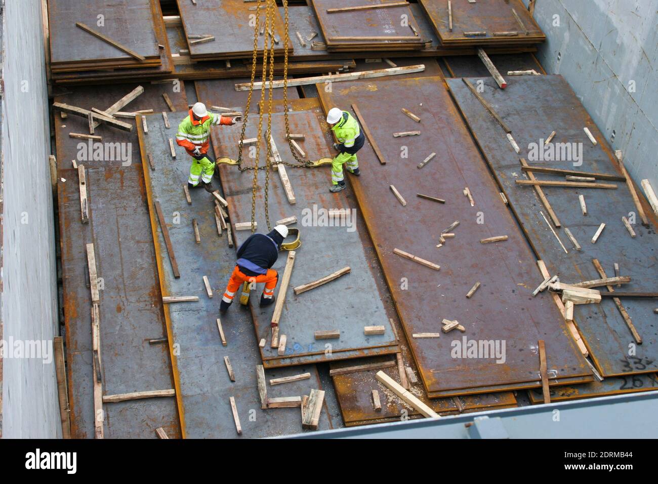 Stevedore load steel to ship in harbour Stock Photo - Alamy