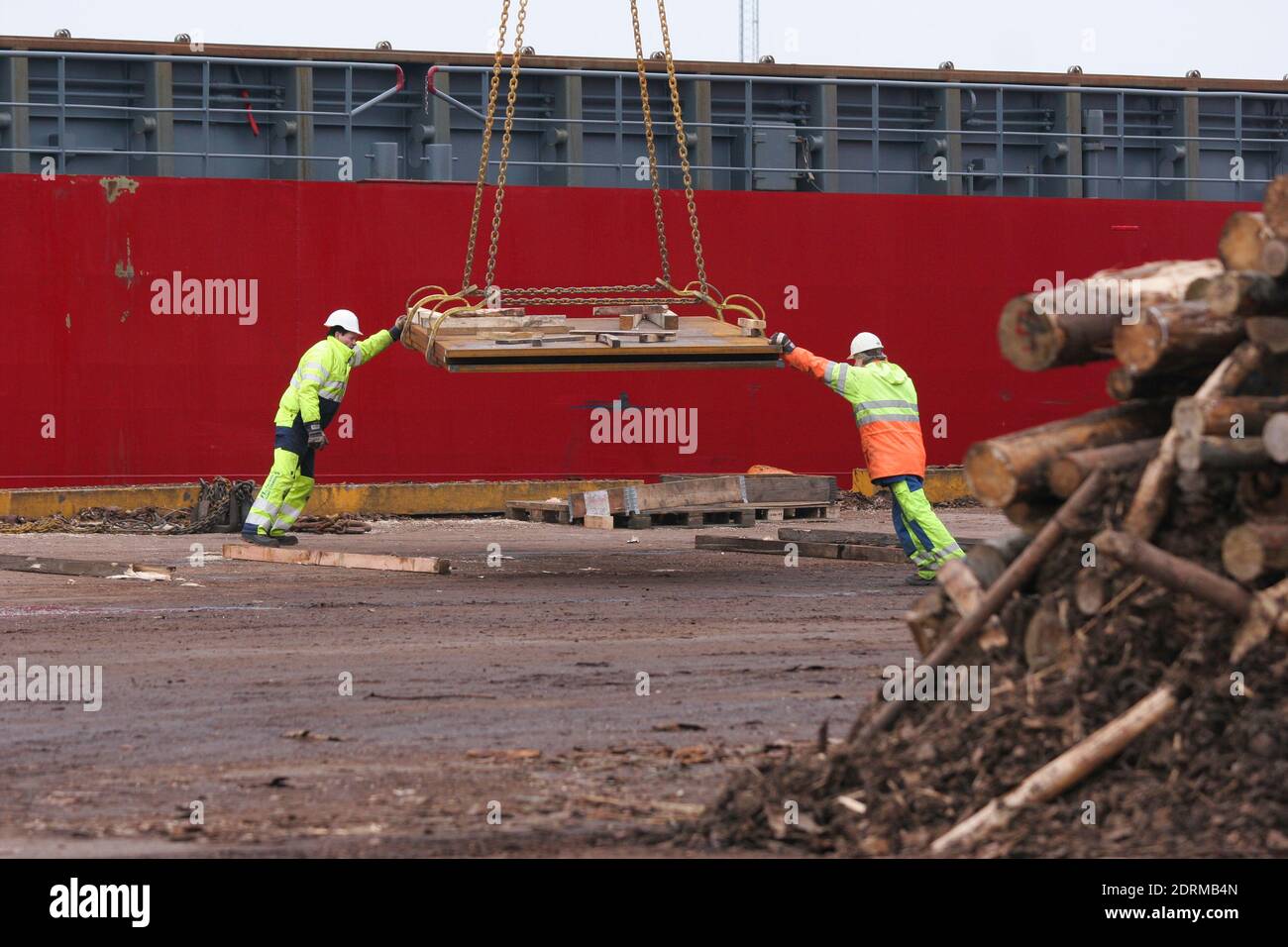 Stevedore load steel to ship in harbour Stock Photo - Alamy