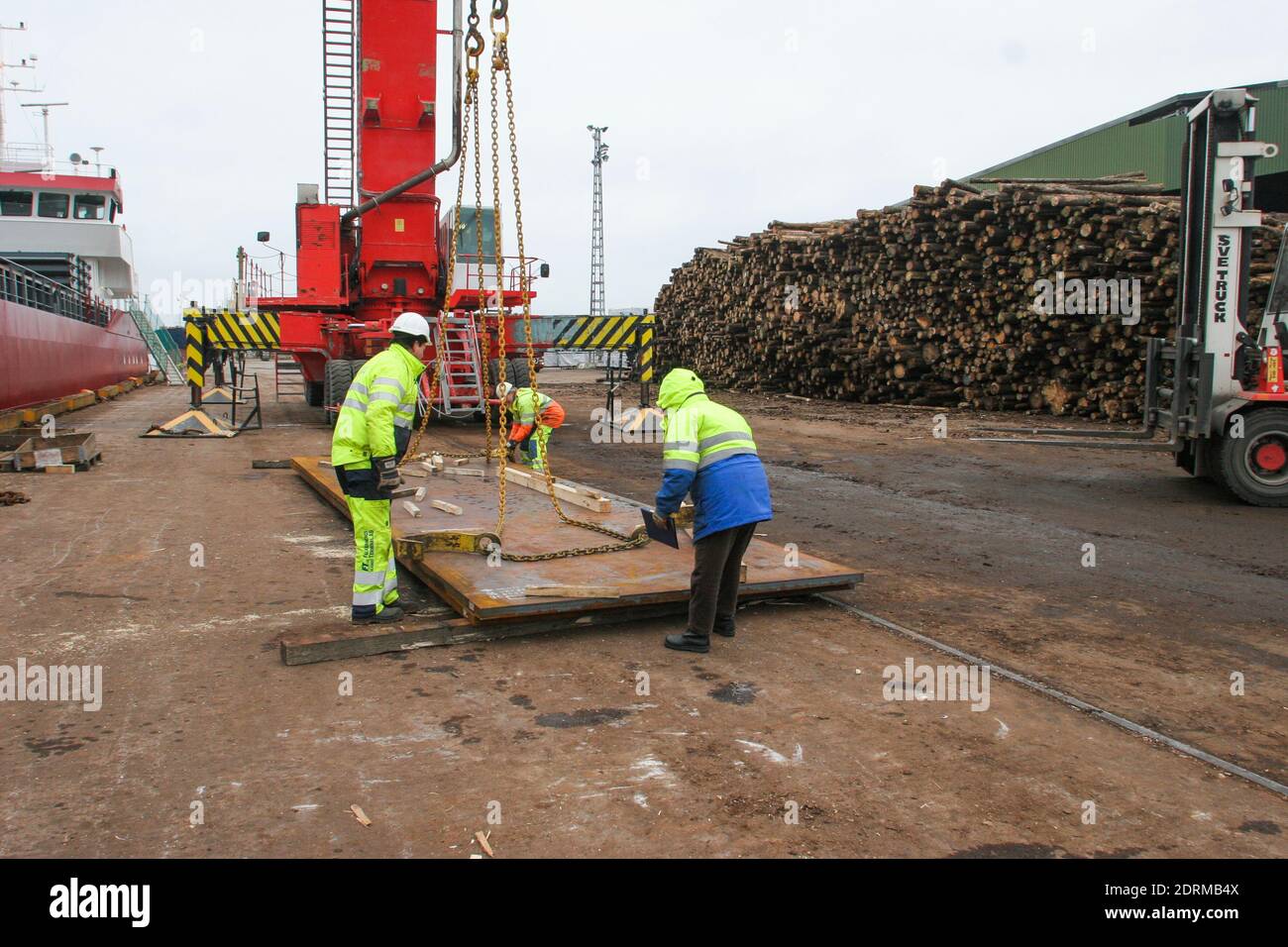 Stevedore load steel to ship in harbour Stock Photo - Alamy