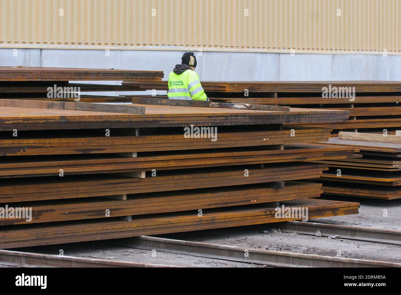 Stevedore load steel to ship in harbour Stock Photo - Alamy