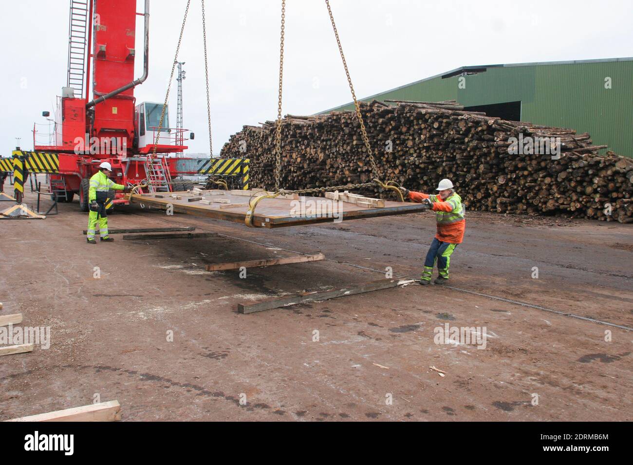Stevedore load steel to ship in harbour Stock Photo - Alamy
